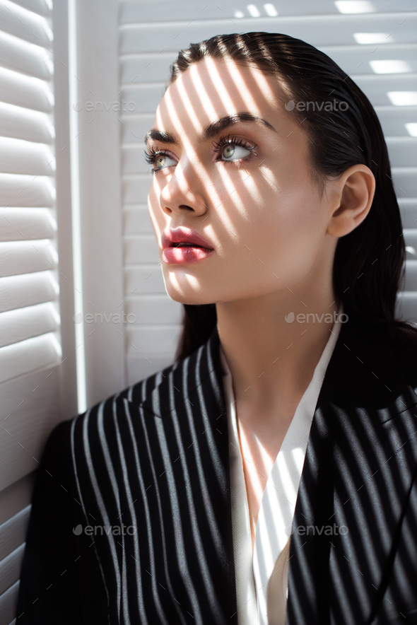 beautiful fashionable woman in black suit with shadows on face Stock ...