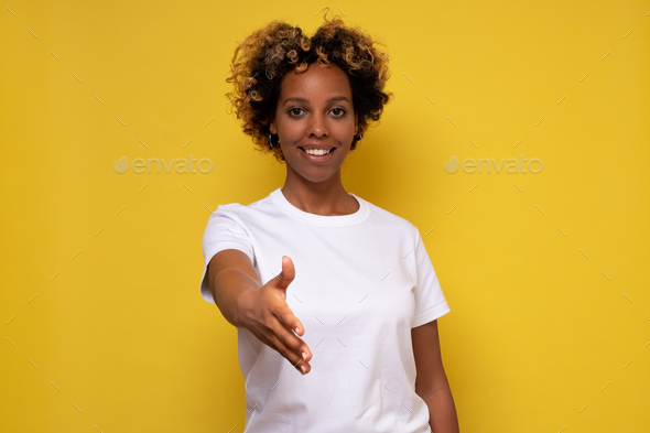 Young beautiful affrican woman smiling friendly offering handshake as ...
