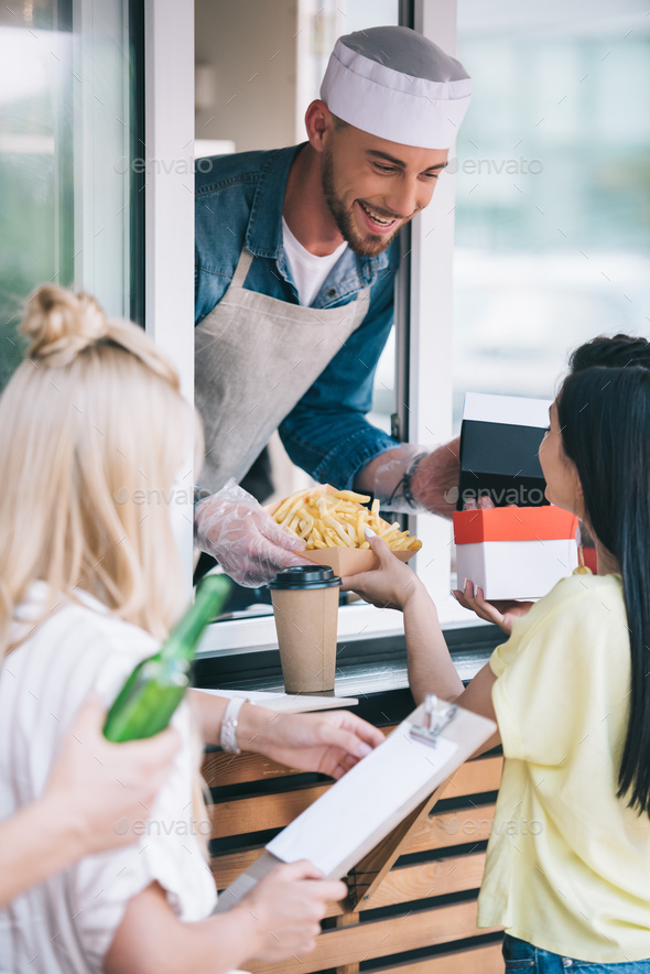 happy chef giving french fries to customer from food truck Stock Photo ...