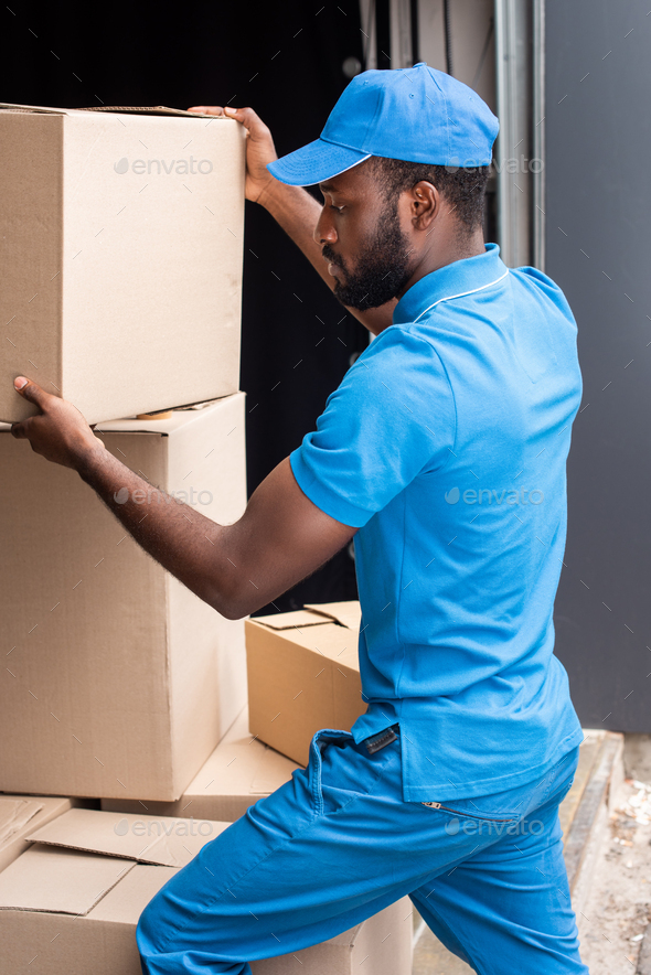 african american delivery man putting boxes on each other Stock Photo ...