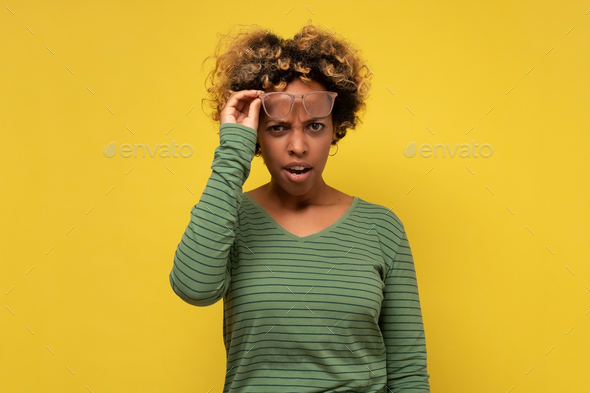 african woman wears glasses looks with terror at camera as notices ...