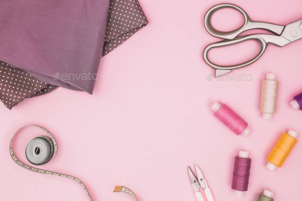 Pink background with sewing accessories and fabric, tailoring supplies ...