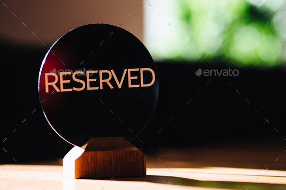 Wooden reserved sign with capital letters on dining restaurant table ...