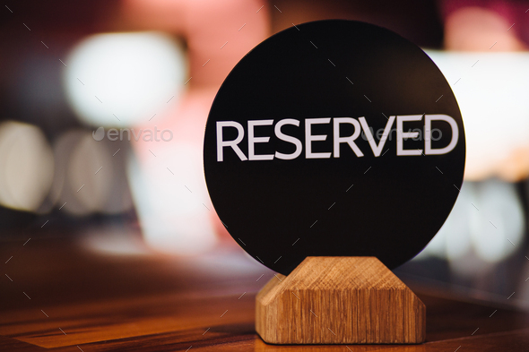Close up of restaurant reserved table sign on table. Inscription ...