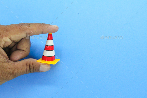 hands holding red, white and yellow construction cones. Stock Photo by ...