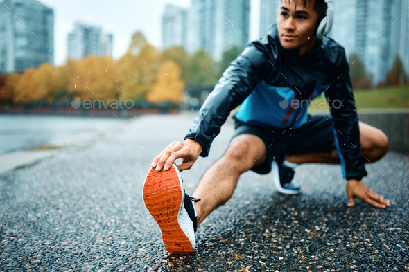 Close up of sportsman doing stretching exercise on the road during ...