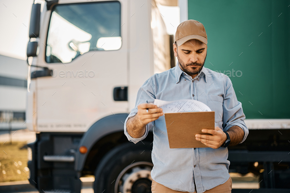 Truck driver going through paperwork before the ride. Stock Photo by ...
