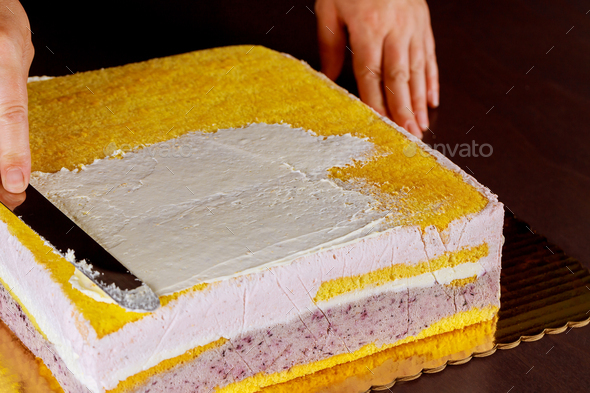 Putting icing cream on cake layer. Making layer sponge cake. Stock ...