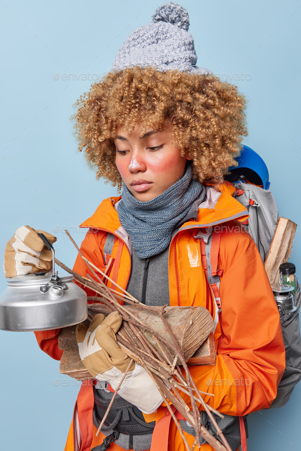 Photo of serious female camper dressed in winter clothes poses with ...