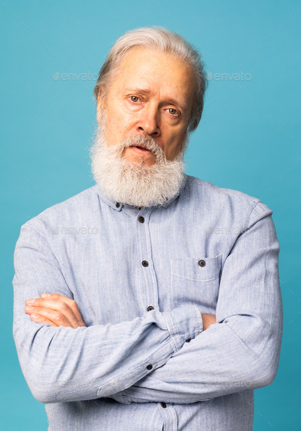 Portrait of unhappy grumpy pissed off senior mature man on blue ...