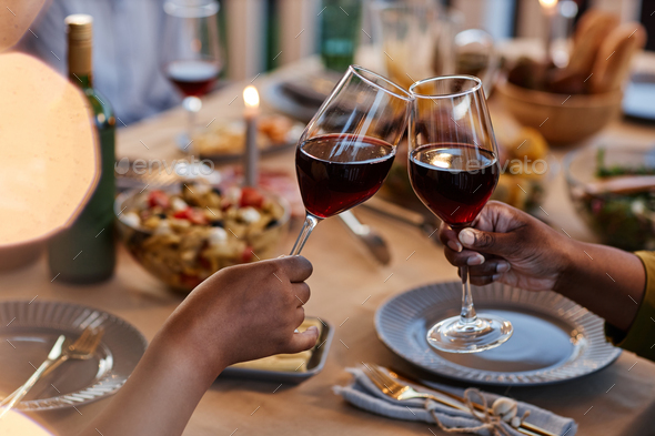 Toasting with Wine at Dinner Table Stock Photo by seventyfourimages