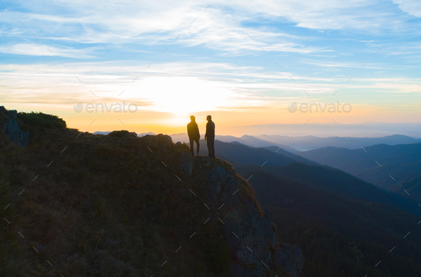 The couple standing on the mountain on the sunrise background Stock Photo by artemp3