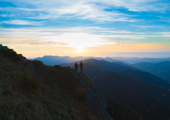 The couple standing on the mountain on the sunrise background Stock Photo by artemp3