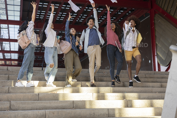 Group of multiracial students throw up college notes finishing the ...