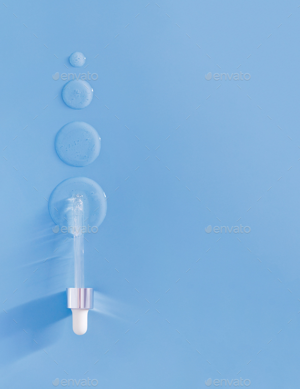 pipette drops of serum on blue background Stock Photo by ekaterinak11