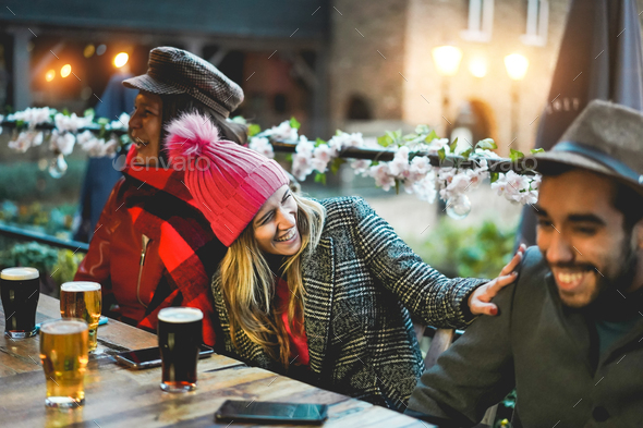 Young people having fun drinking beer at pub restaurant - Soft focus on ...