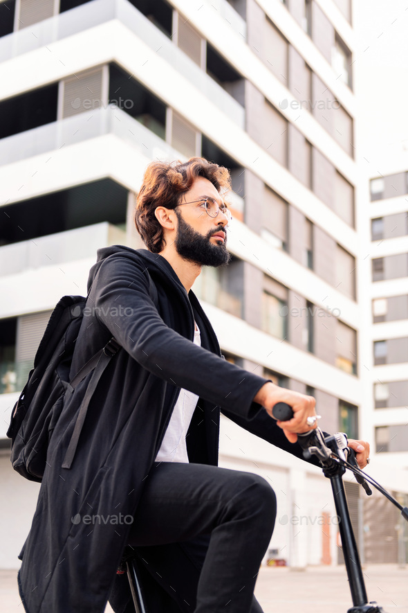 stylish bearded man riding a bike through the city Stock Photo by Raul ...