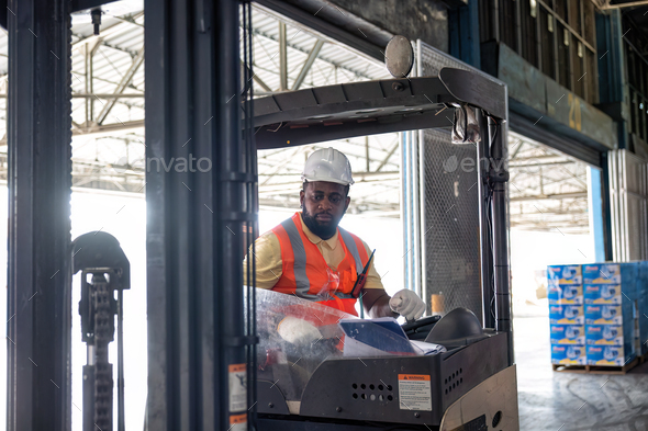 Forklift Truck Operator Lifts Pallet Cardboard Boxes On a Shelf by ...