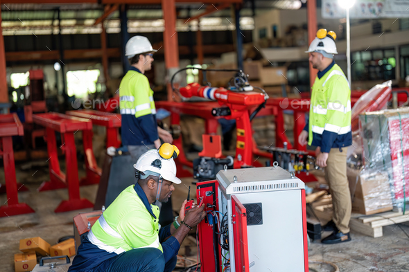 Electrician at robot factory measurement with multimeter testing ...