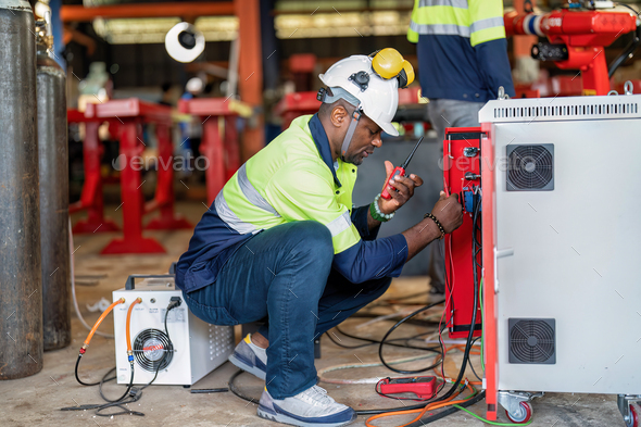 Electrician at robot factory measurement with multimeter testing ...