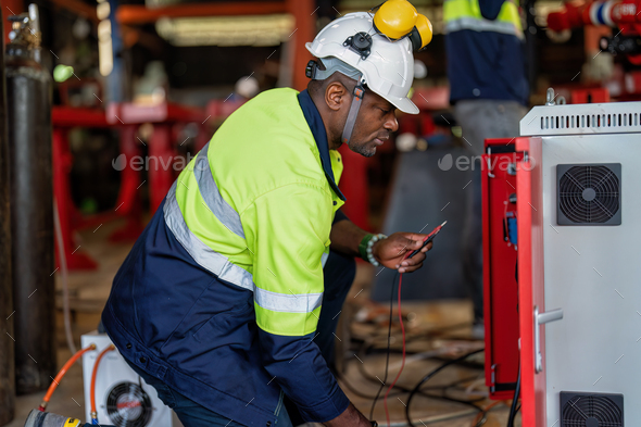 Electrician at robot factory measurement with multimeter testing ...
