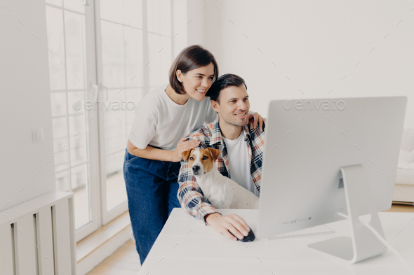 young husband and wife focused in modern computer, make shopping or ...