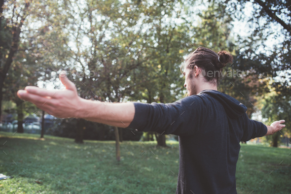 Back view young man outdoors spreading arms wide open feeling free ...