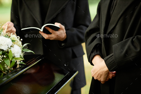 Outdoor funeral ceremony with priest reading prayer Stock Photo by ...