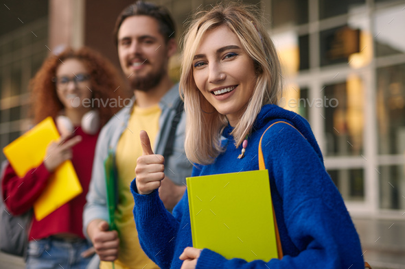 Glad female student approving university education Stock Photo by kegfire