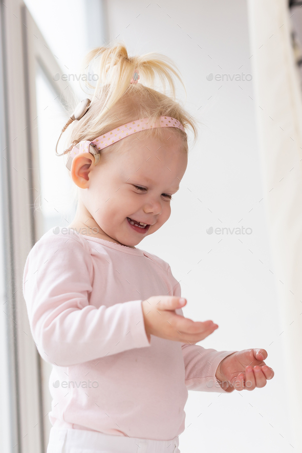Cochlear implant for baby. Deaf child with hearing aid at home ...