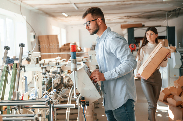 Female helper behind holding wooden sheets. Print house worker in white ...