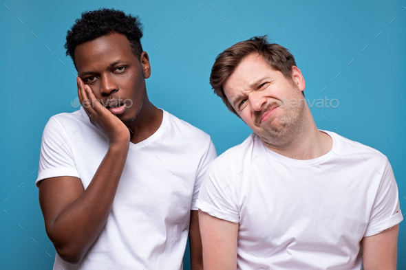portrait of two bored young men, isolated blue background Stock Photo ...