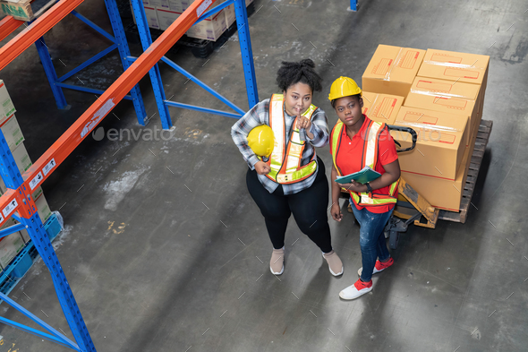 Diverse overweight worker in warehouse hold check sheet pull manual ...