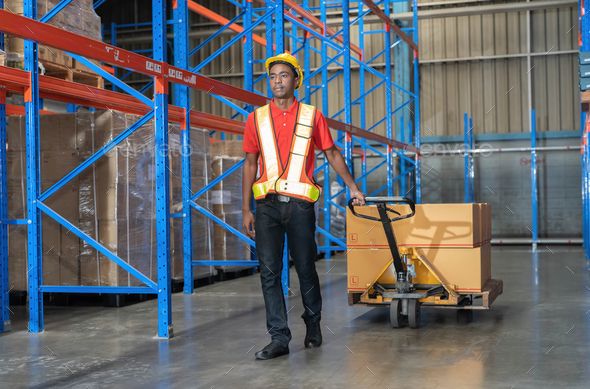 Worker in warehouse pulling hand pallet truck carry boxes looking ...