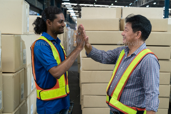 Manager and staff working in warehouse hand punch and check hand after ...