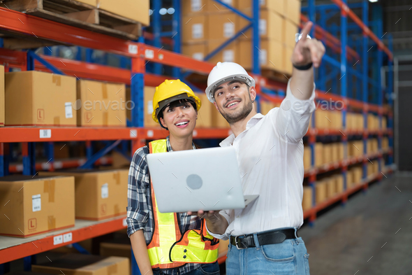 Supervisor and manager hold laptop computer visit warehouse annual ...