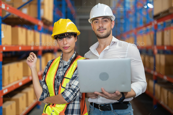 Supervisor and manager hold laptop computer visit warehouse annual ...