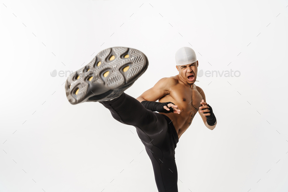 Young shirtless sportsman kicking while working out Stock Photo by ...