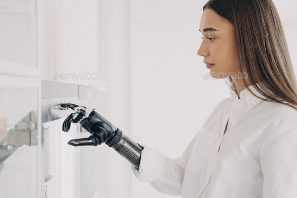 European handicapped woman is cooking. Robotic cyber hand is switching ...