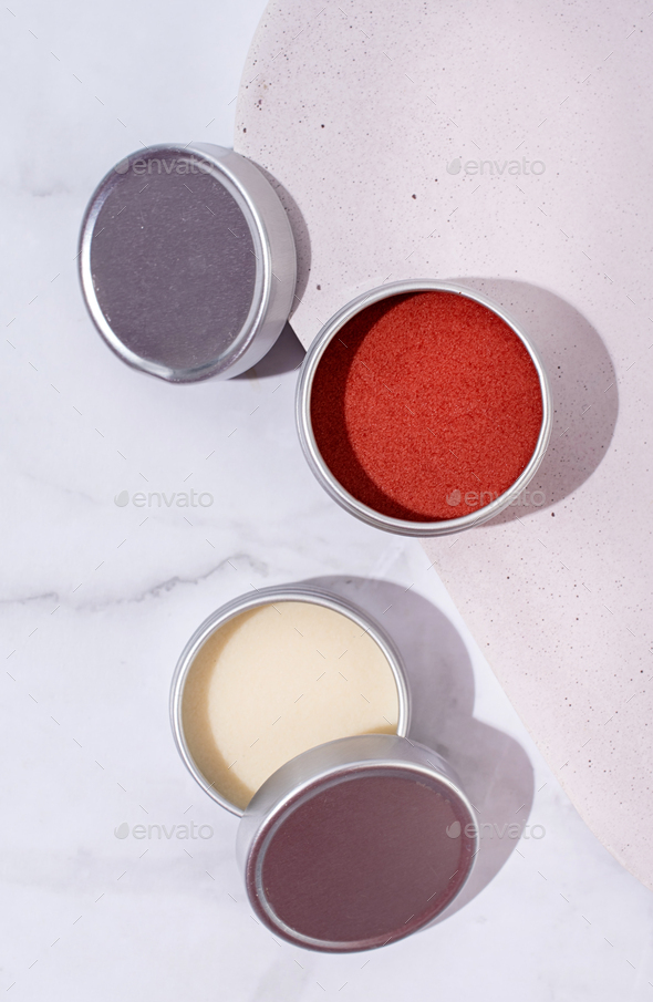 colorful lip balms in round tin cases with shadow overlay, mockup ...