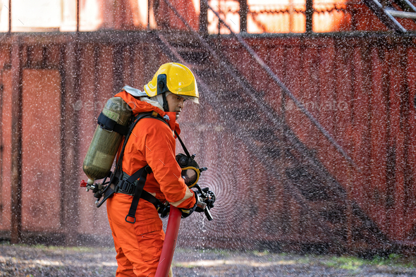 Fireman wearing fire protection suite and oxygen tank exercise hold ...