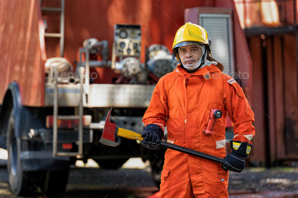 Fireman wearing fire protection suite and oxygen tank exercise hold axe ...