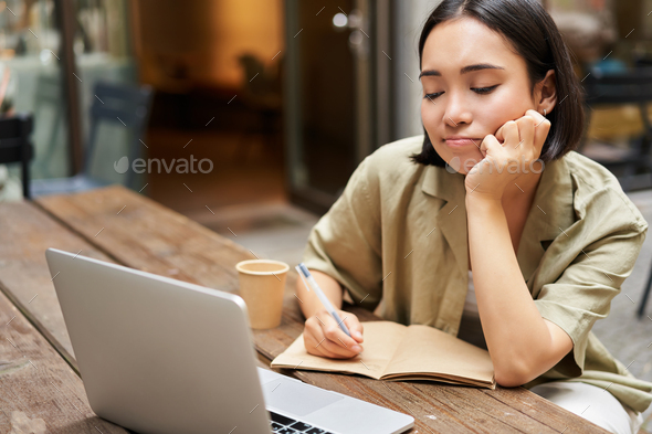 Portrait of young korean girl making notes, listening online meeting ...