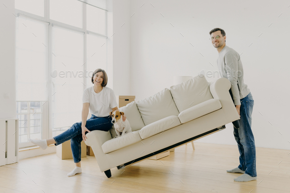 Husband and wife carry sofa, furnish living room after renovation ...