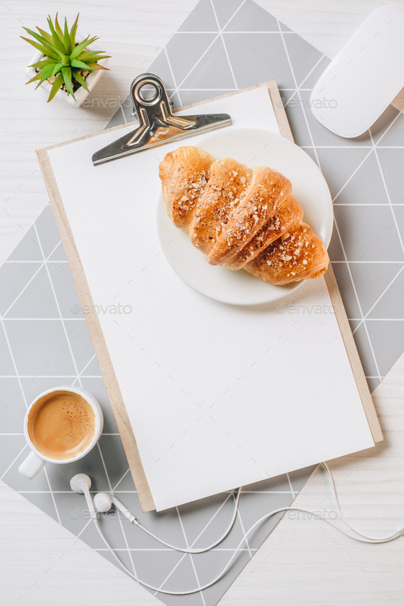flat lay with croissant, coffee cup, computer mouse and blank clipboard ...