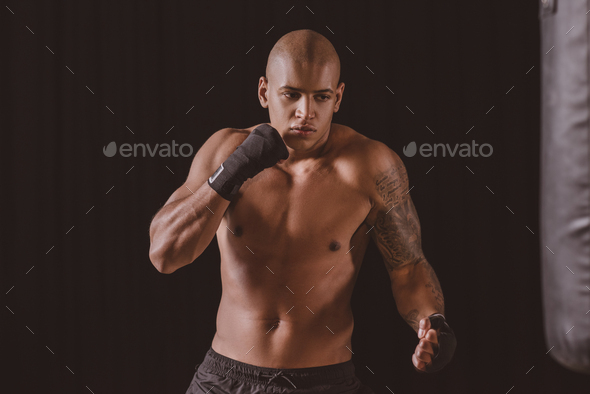 male boxer in boxing bandage training with punching bag at gym Stock ...