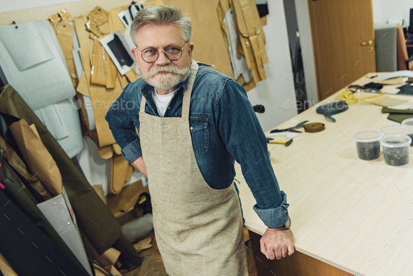 high angle view of happy middle aged male craftsman in apron posing at ...