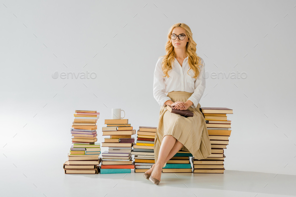 beautiful adult woman sitting on pile of retro books Stock Photo by ...