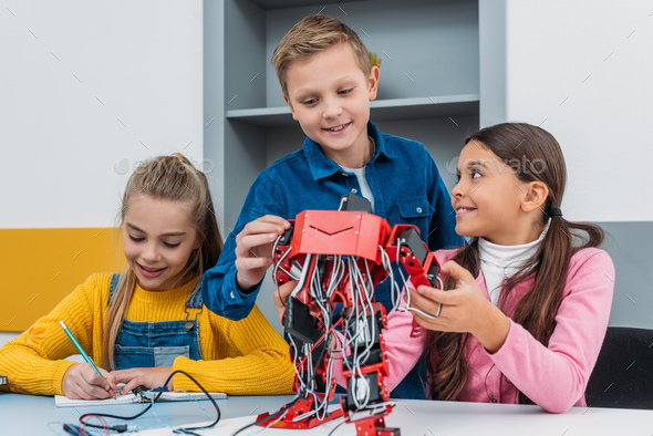 smiling schoolchildren making electric robot in stem class Stock Photo ...