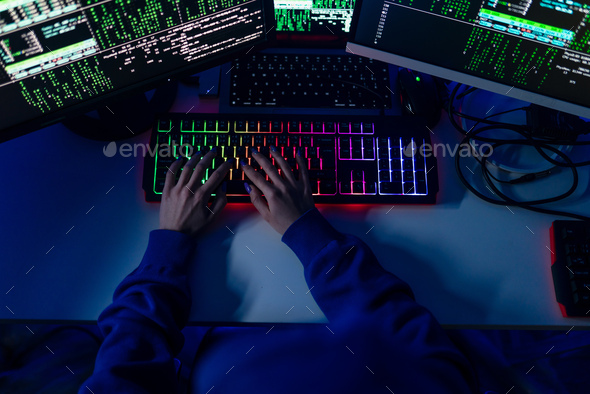 Close-up of woman hacker hands at keyboard computer in the dark room at ...